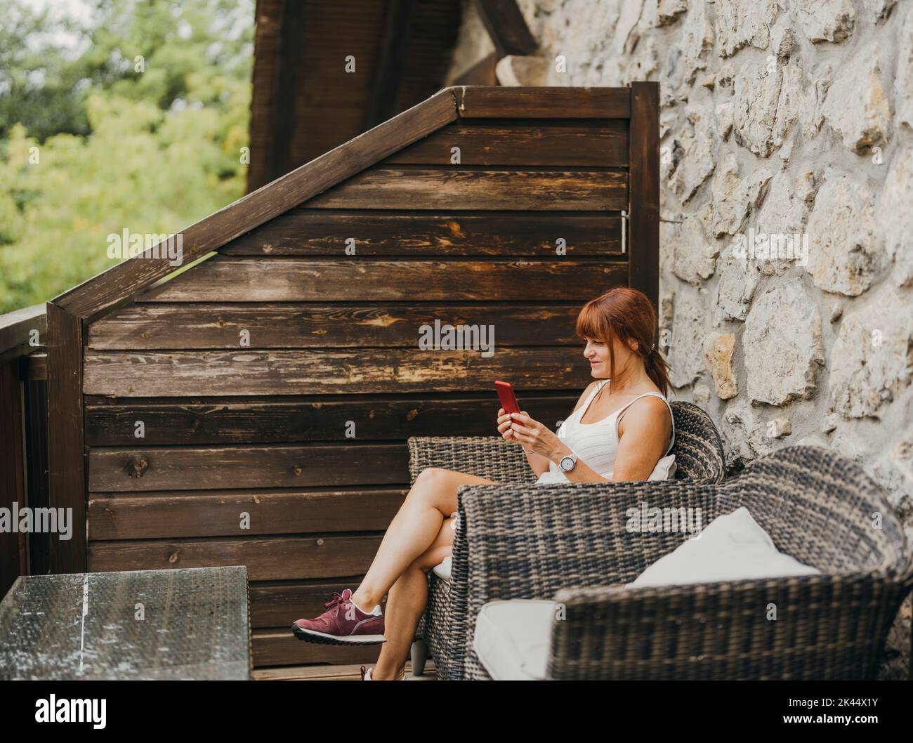 woman with her mobile phone sitting on a hotel room terrace Stock Photo ...