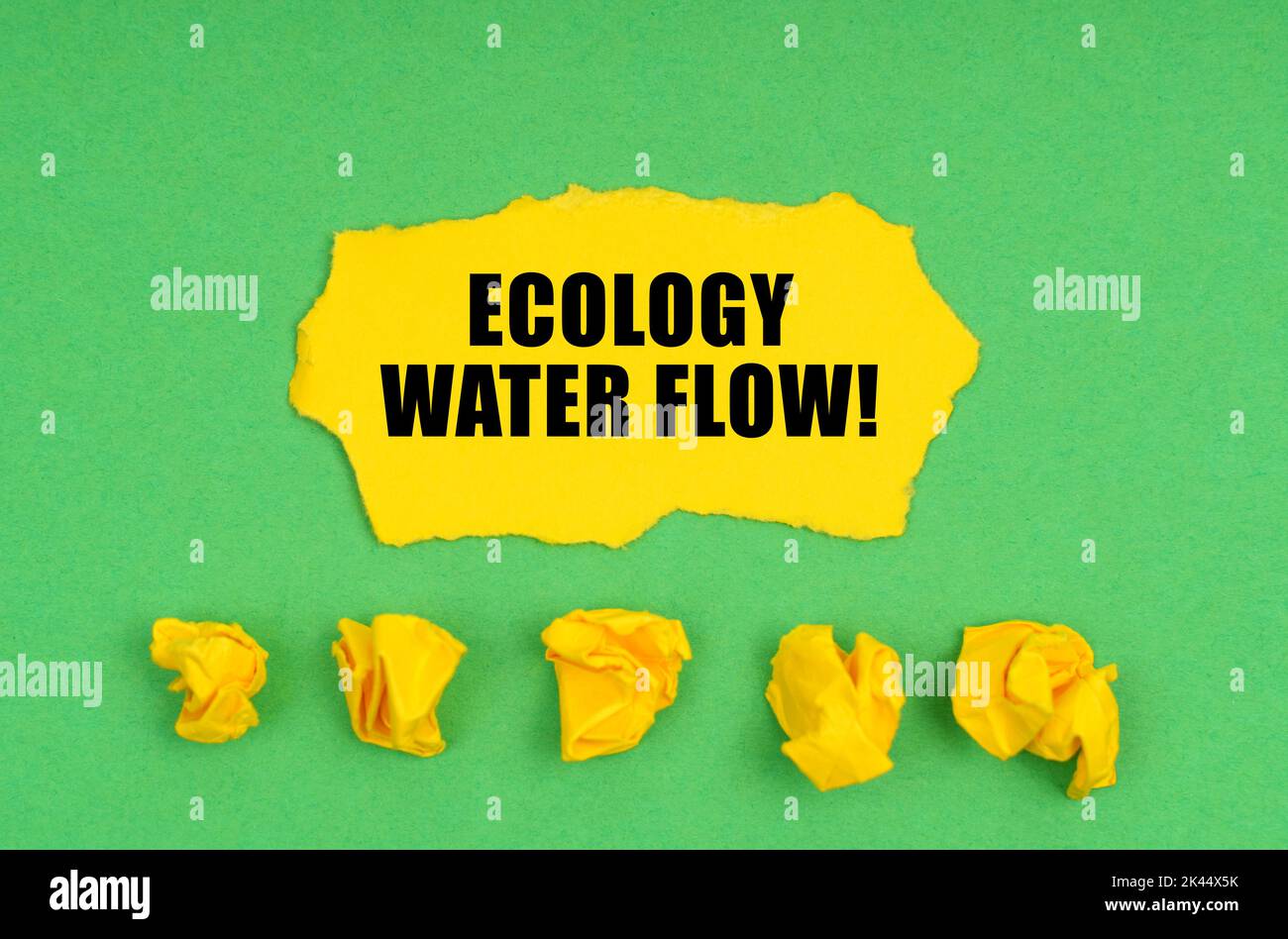 Ecology concept. On a green background, crumpled yellow paper and a ...