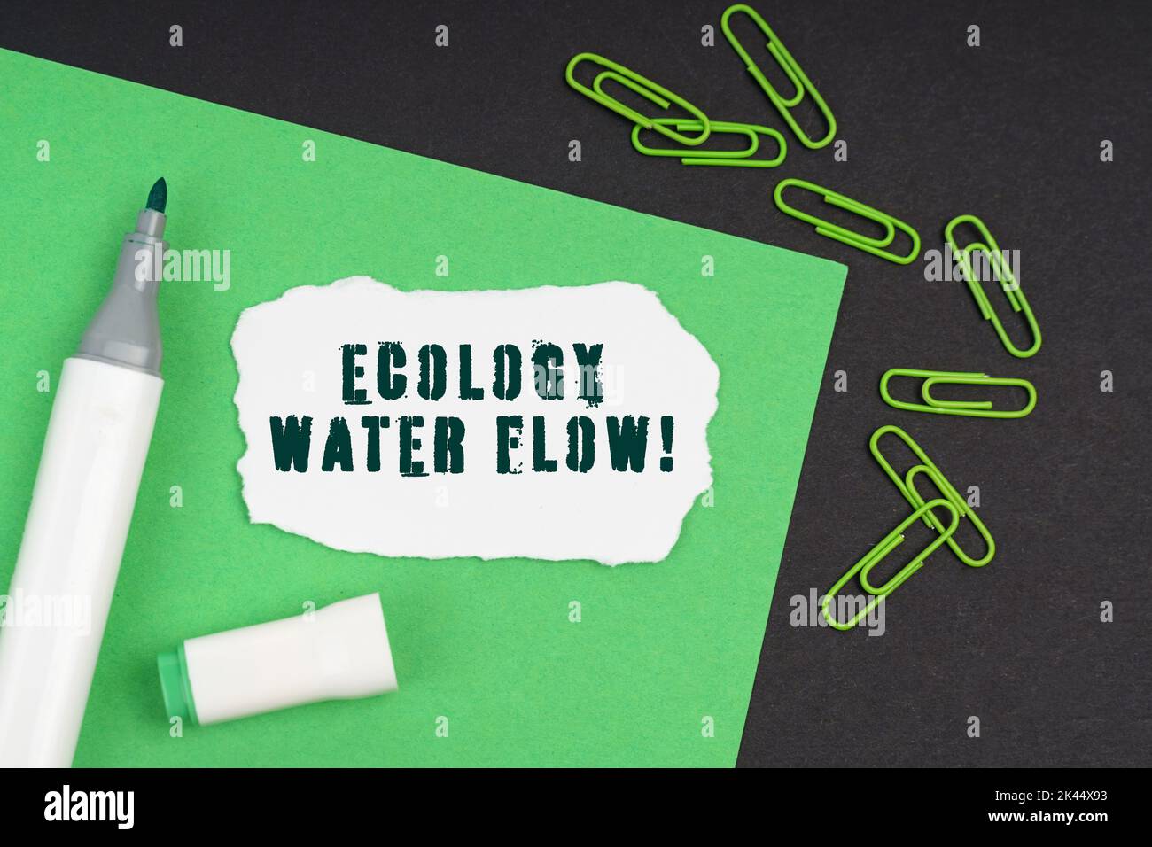 Ecology concept. On a black background, a marker, paper clips, a sheet ...