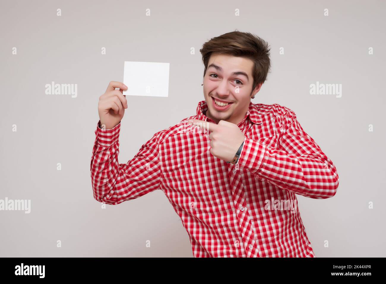 Happy smiling young business man showing blank signboard, isolated over ...