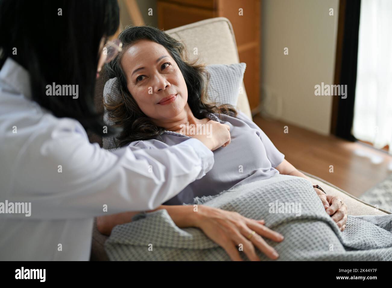 A professional Asian female doctor cardiologist checking up her elderly ...