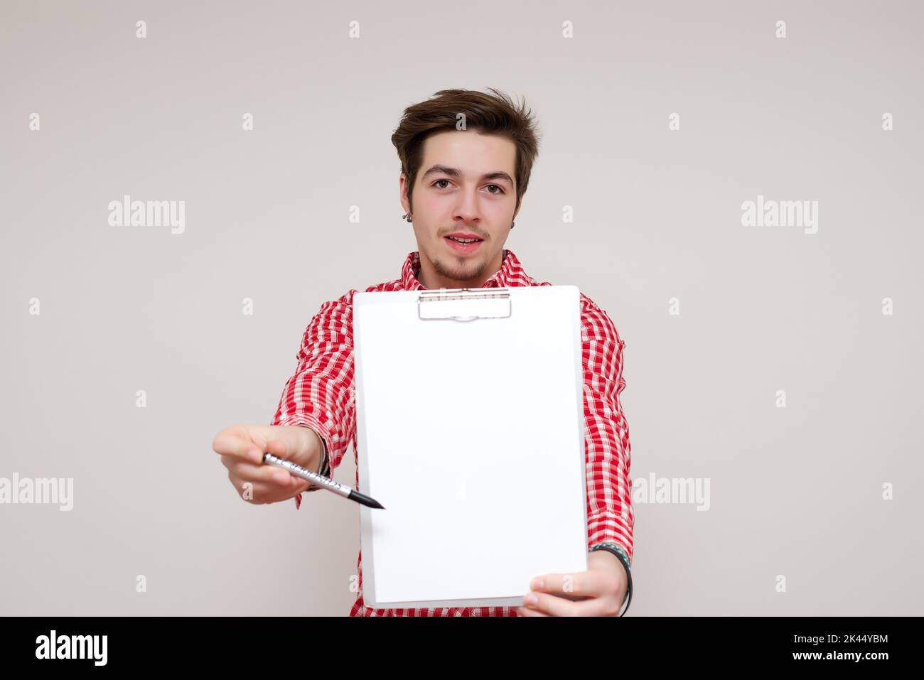 Young man with red shirt and blank board isolated on white stock photo ...