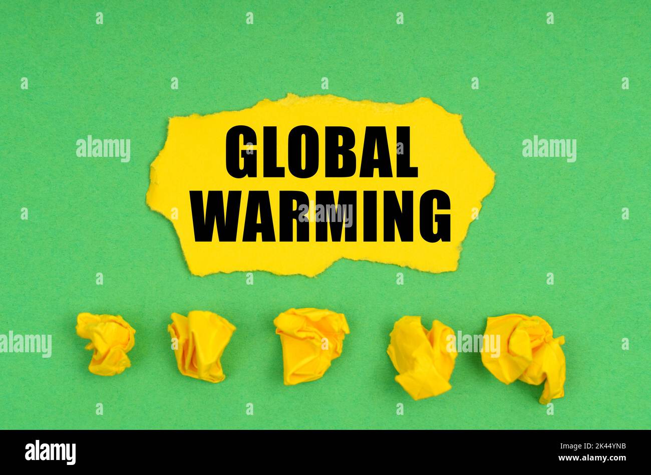 Ecology concept. On a green background, crumpled yellow paper and a ...