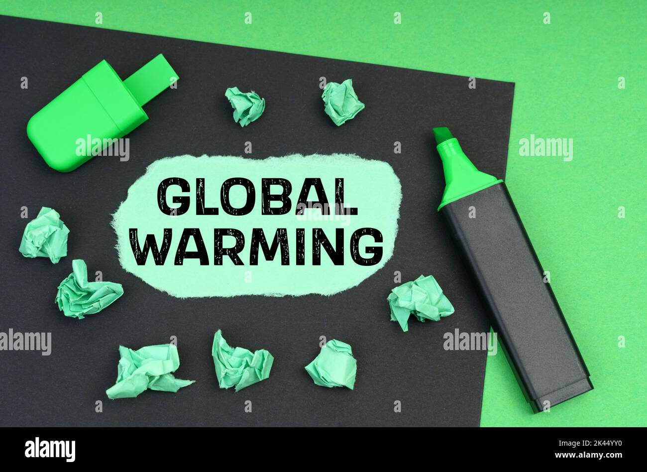 Ecology concept. On a green background, a marker, a black sheet and ...