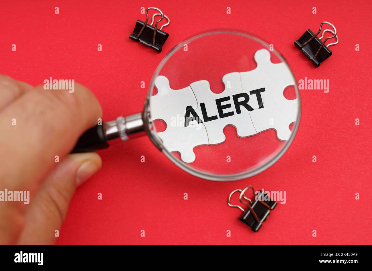 Business concept. A man looks through a magnifying glass at puzzles ...