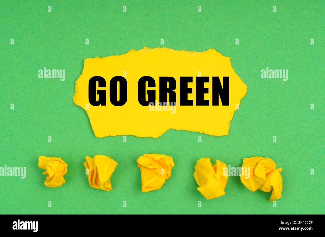 Ecology concept. On a green background, crumpled yellow paper and a ...