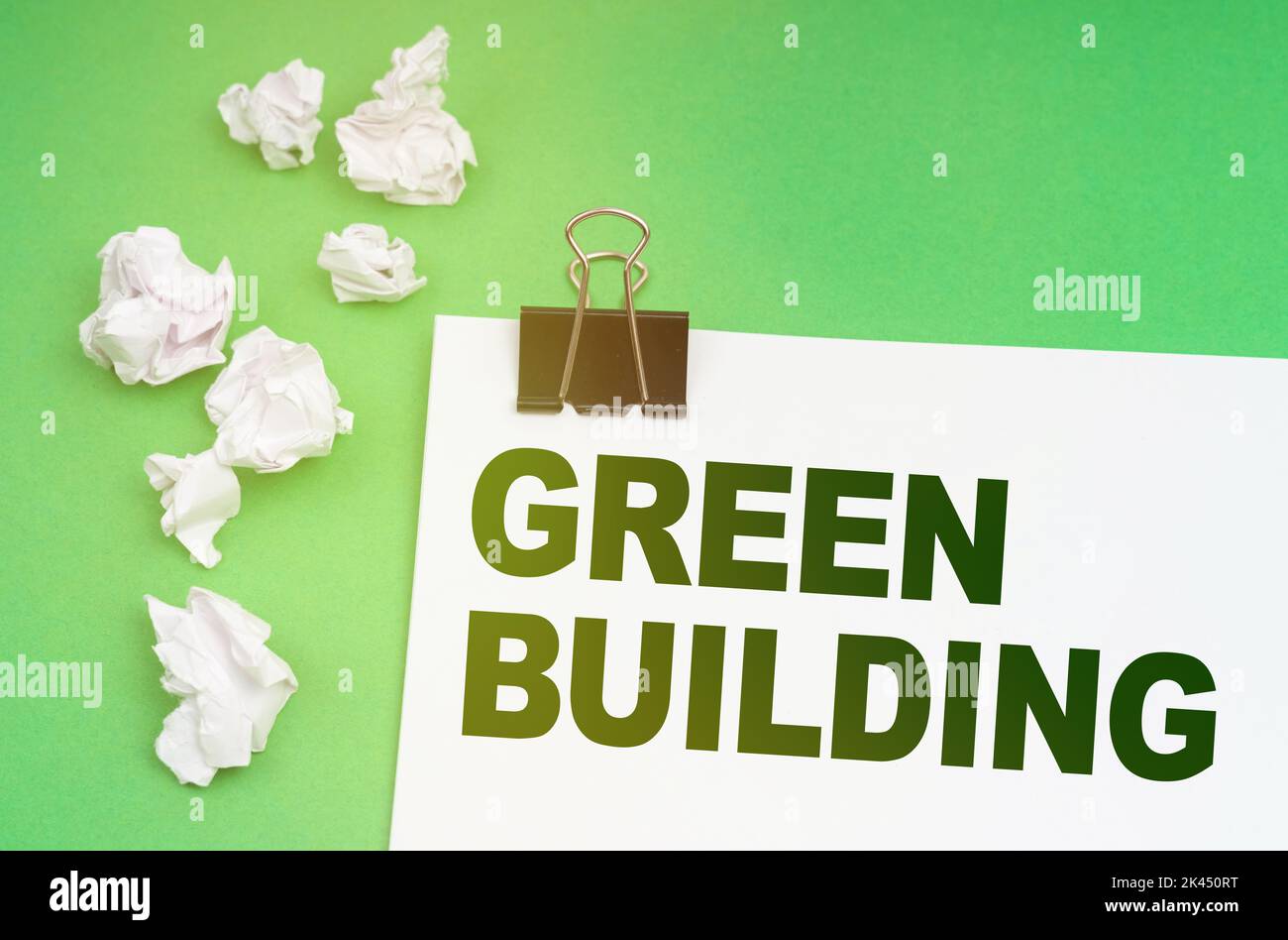 Ecology concept. On a green background, crumpled paper and a sheet with ...