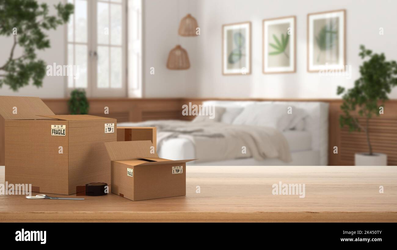 Wooden table, desk or shelf with stack of cardboard boxes over blurred ...