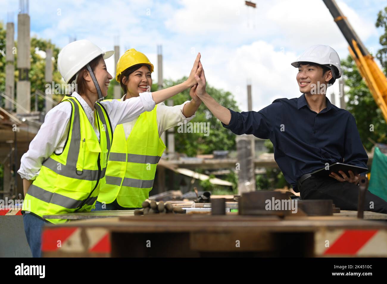 Group of young architect giving high five together, celebrating success ...