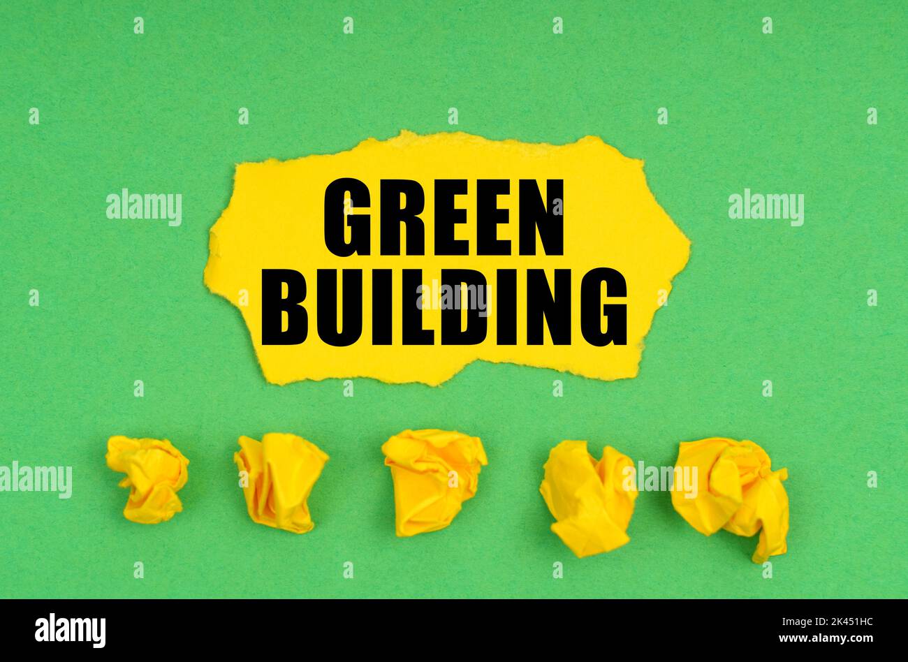 Ecology concept. On a green background, crumpled yellow paper and a ...