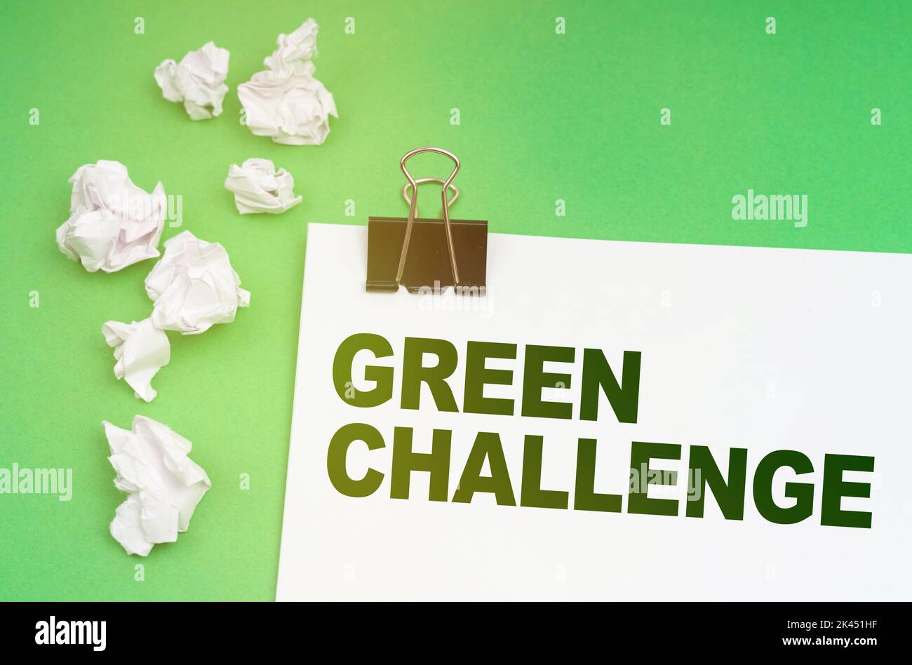 Ecology concept. On a green background, crumpled paper and a sheet with ...