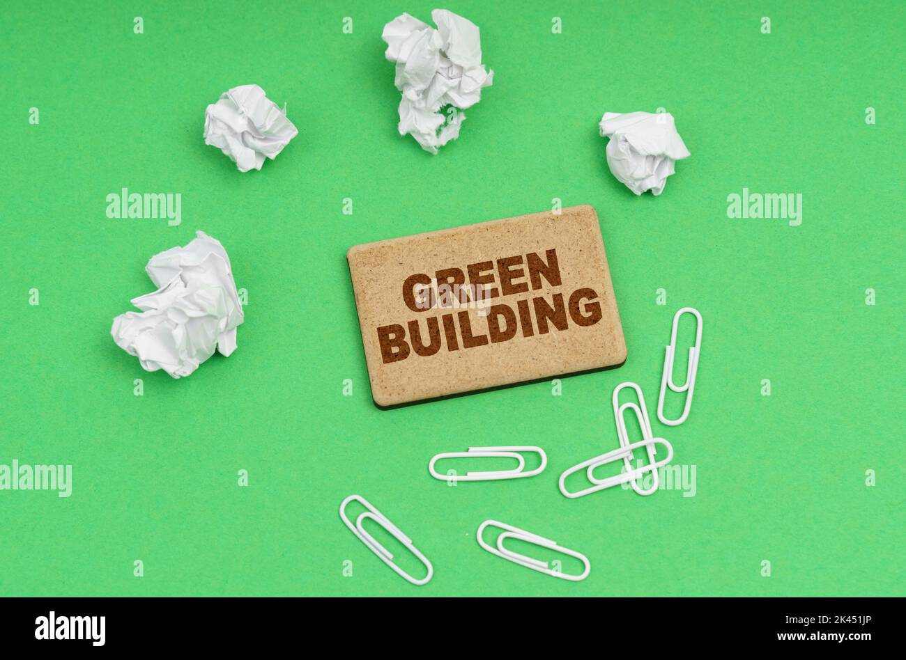Ecology concept. On a green background, crumpled paper, paper clips and ...