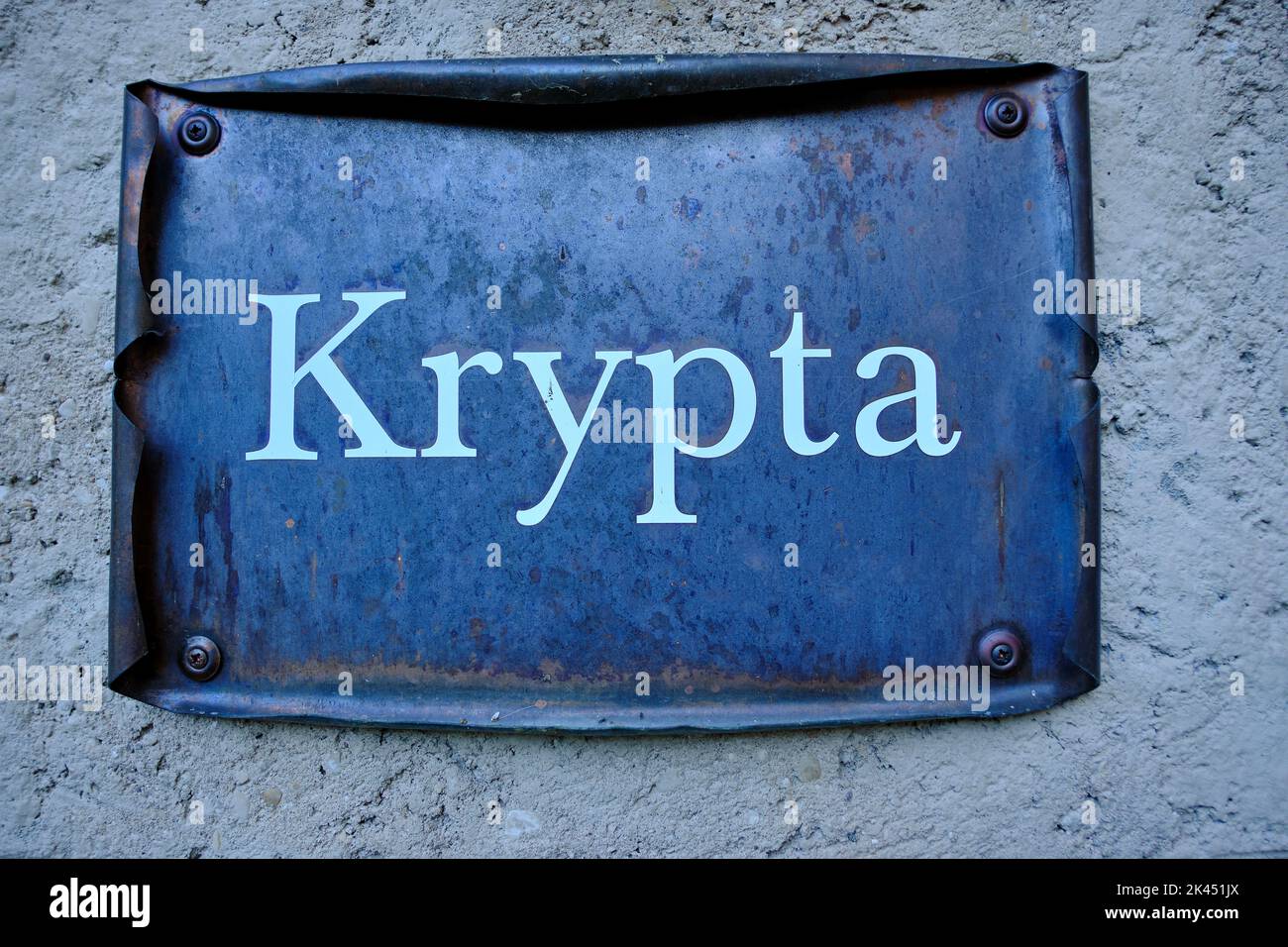 The word Krypta (crypt) on an aged tin sign exposed to the weather and ...