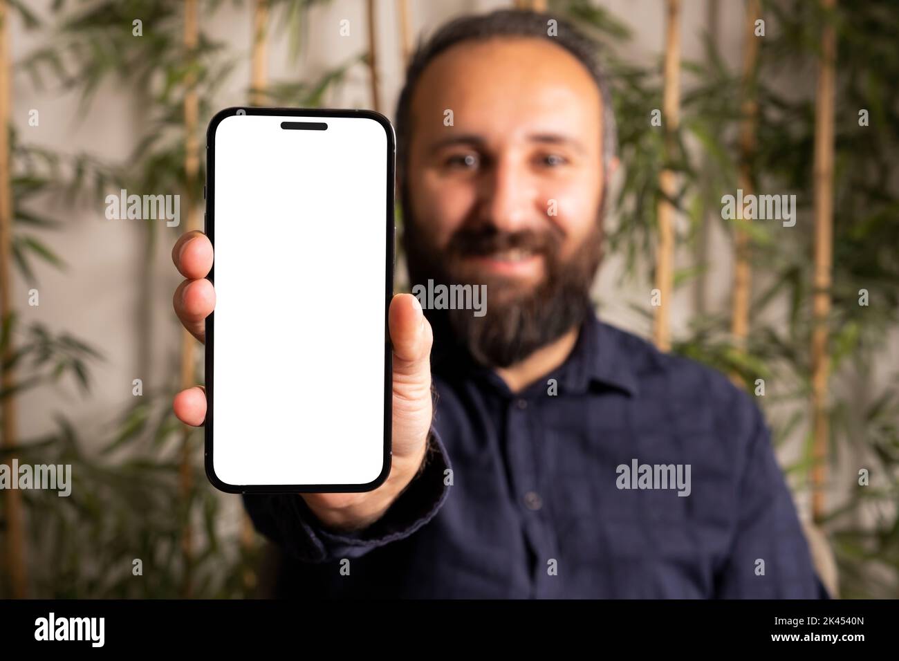 Modern smartphone mock up, caucasian bearded young man holding and ...