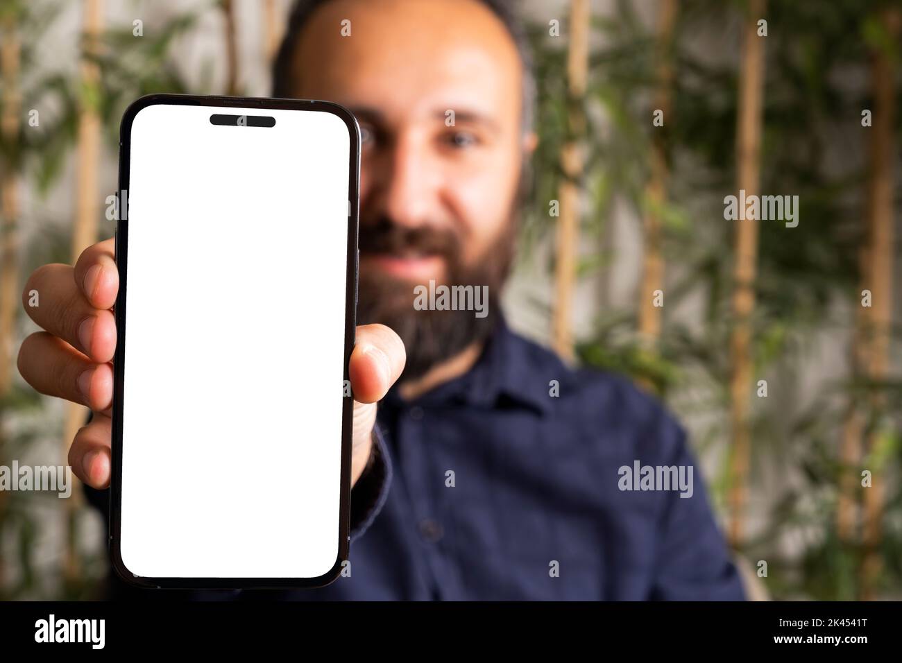 Holding smartphone, caucasian man holding smartphone. Showing white blank screen mock up ...
