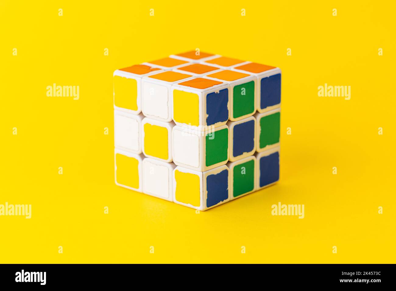 A rubiks cube three sided logic puzzle isolated in yellow background Stock Photo - Alamy