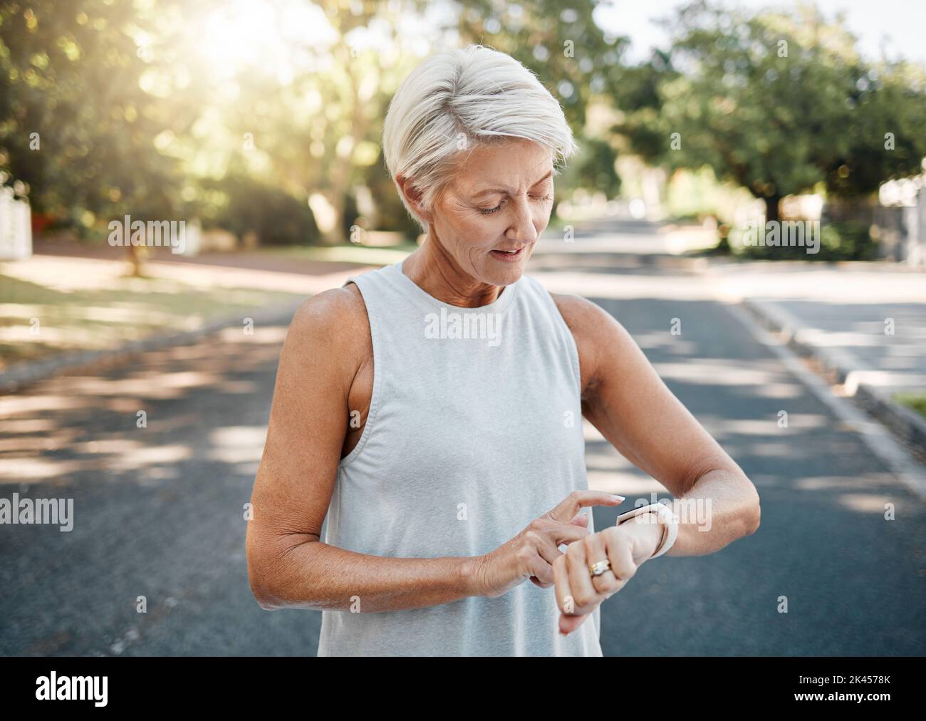 Fitness runner or senior woman with smartwatch check exercise results ...