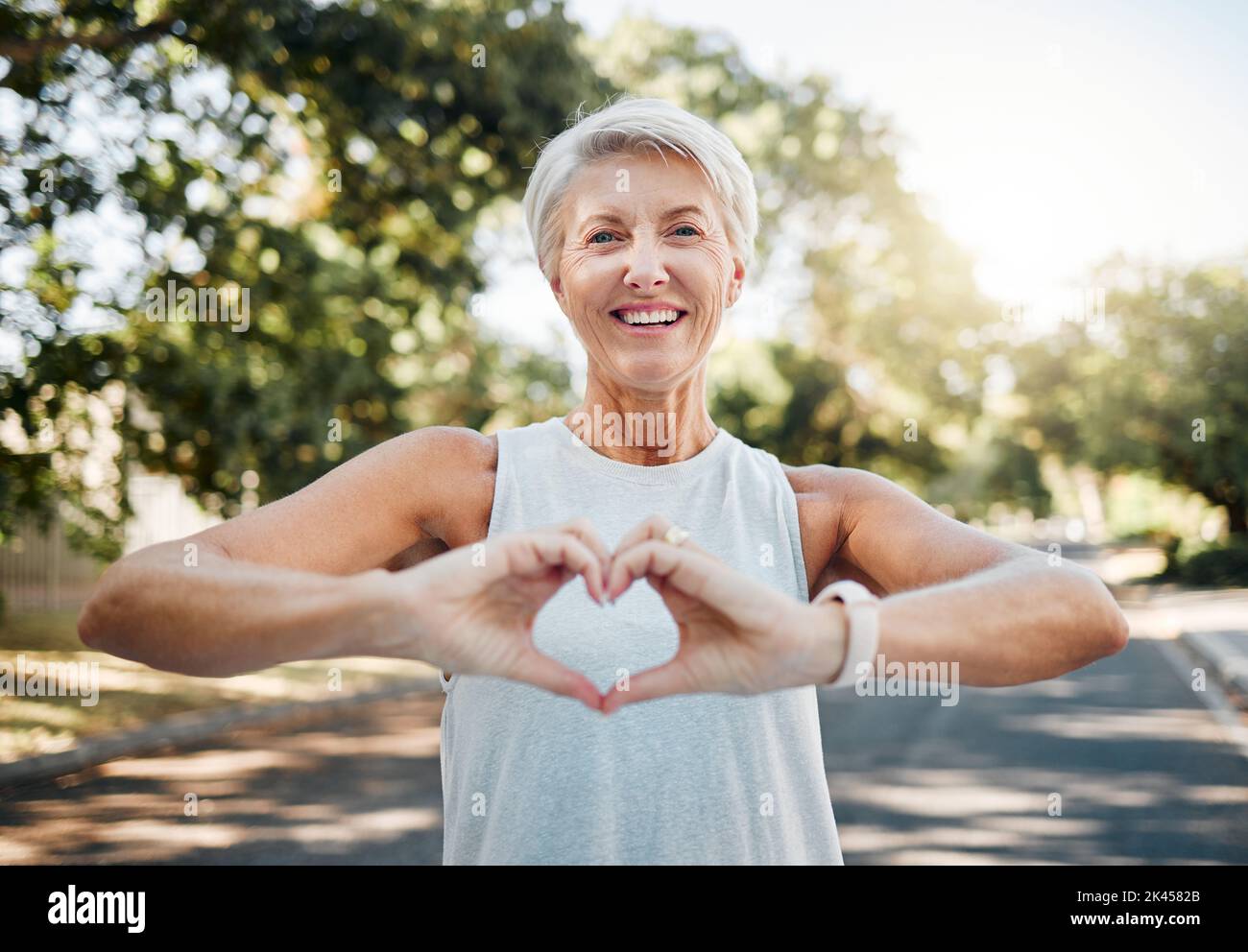Fitness, happy and heart hands of old woman in nature after running for ...
