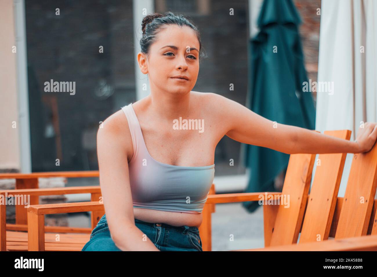 A young girl sitting on the bench with her hand outstretched Stock ...
