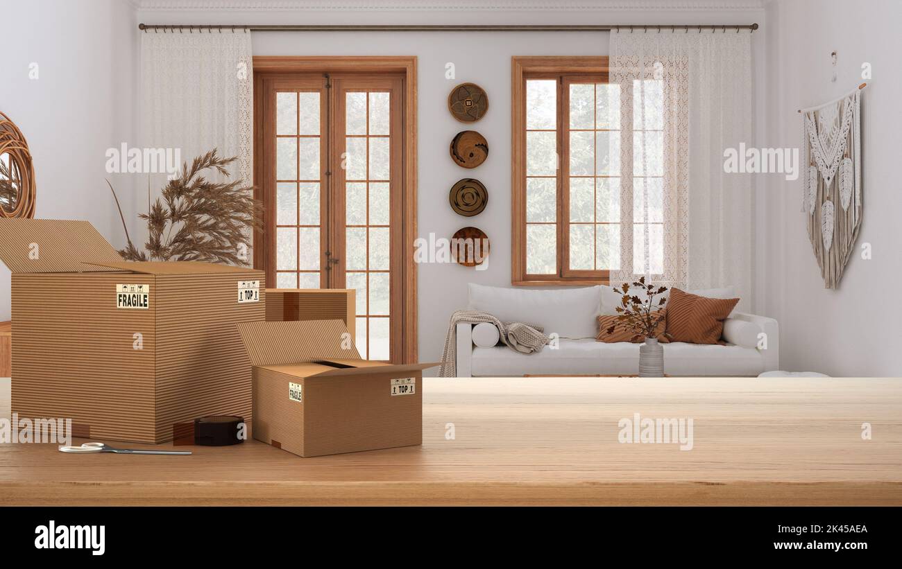 Wooden table, desk or shelf with stack of cardboard boxes over blurred ...