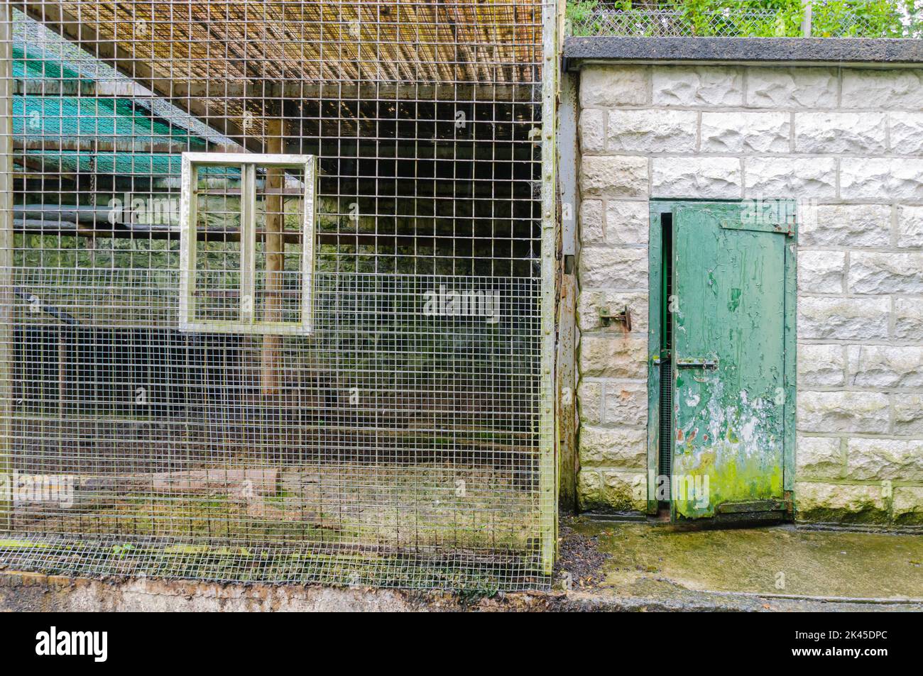Door into an animal pen and cage in an abandoned zoo Stock Photo - Alamy