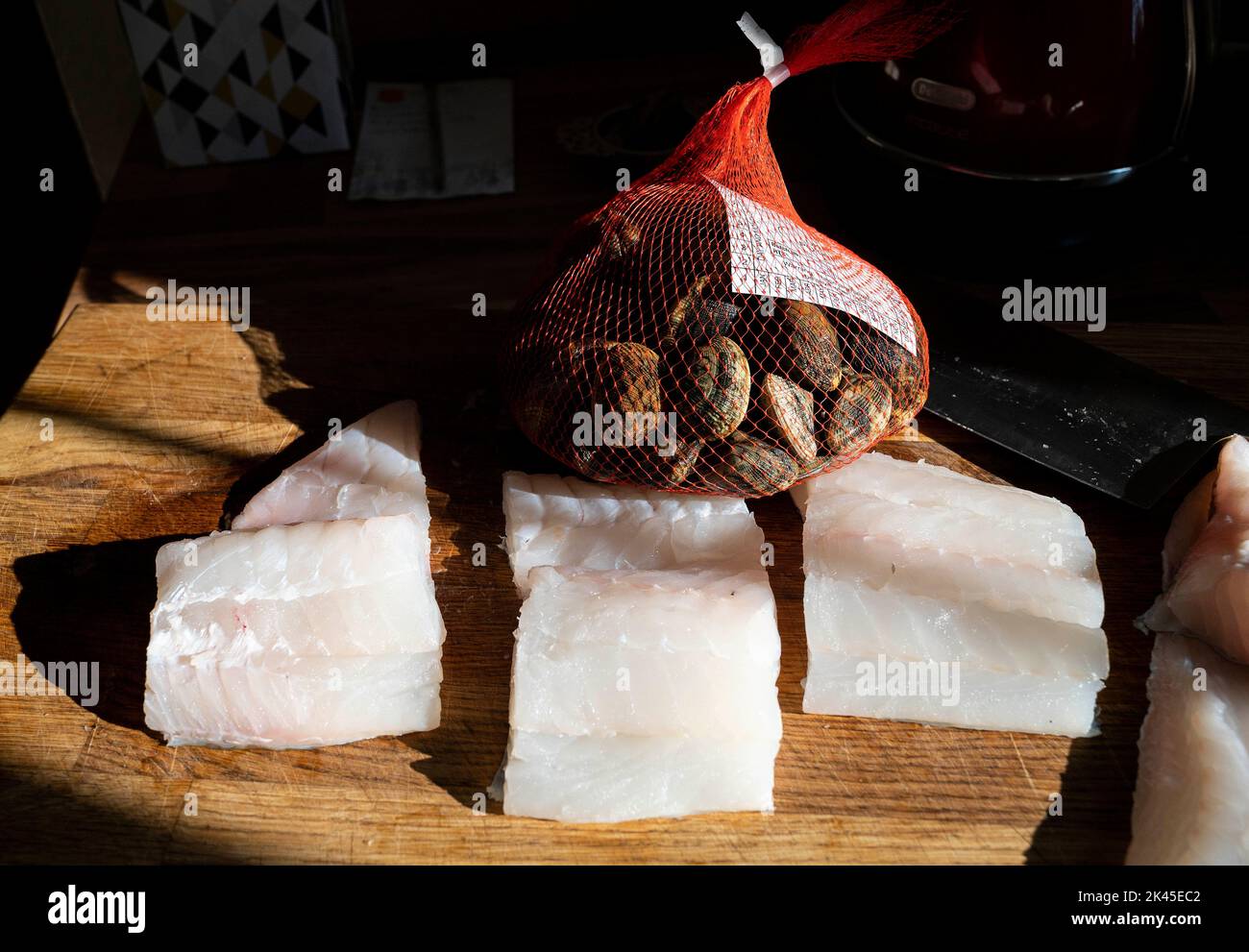 Fresh Cod fillet pinboned and a bag of fresh live clams ready for ...