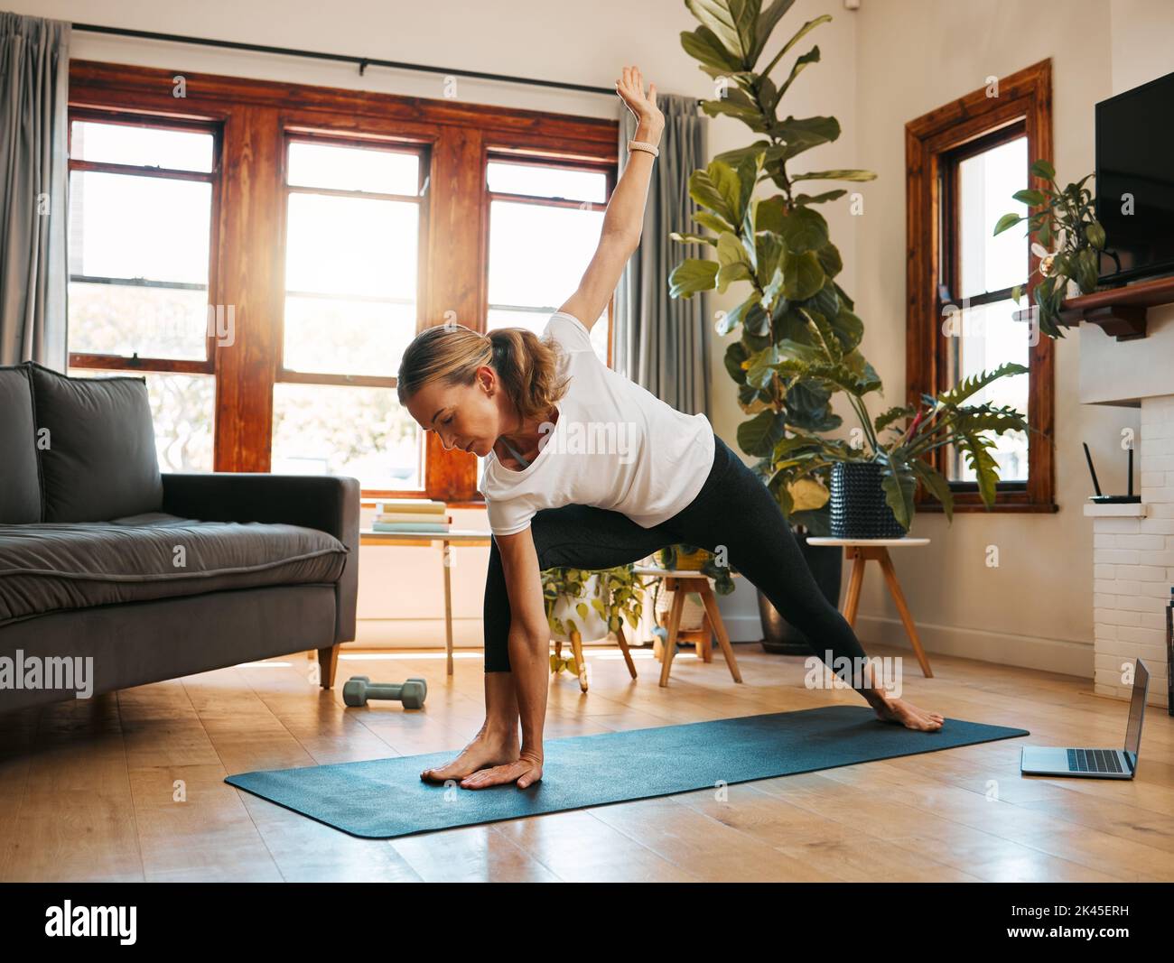 Woman, laptop streaming or home yoga class in relax stretching exercise ...