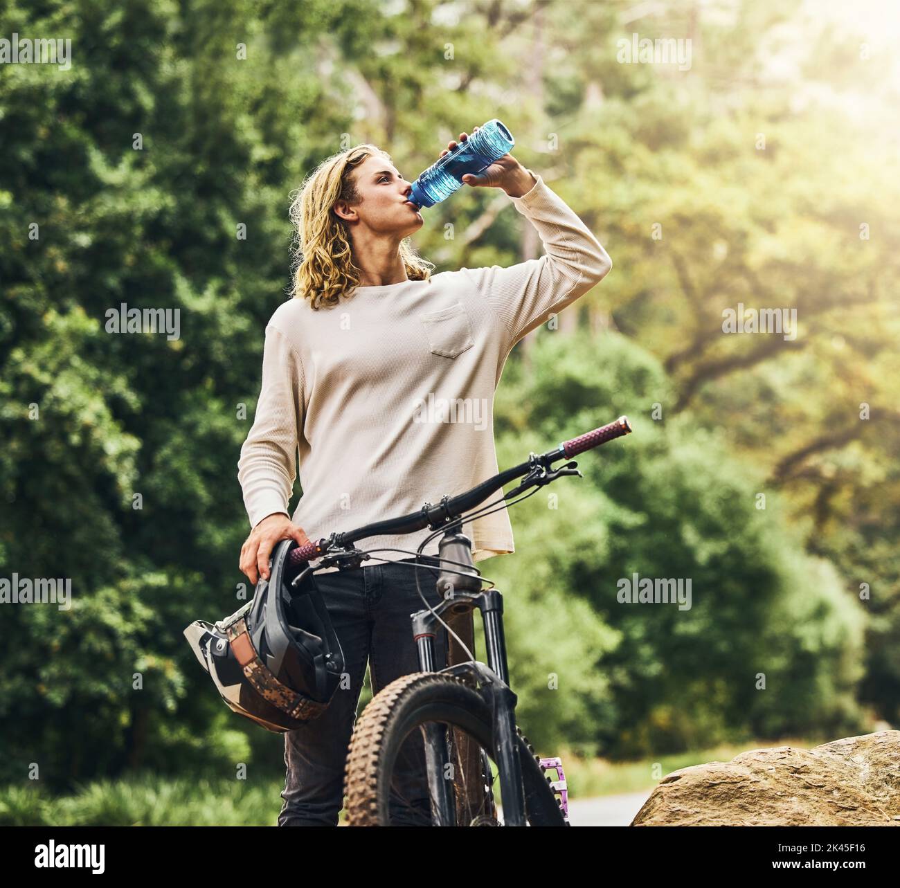 Mountain bike, drinking water and man from Berlin in nature after a ...