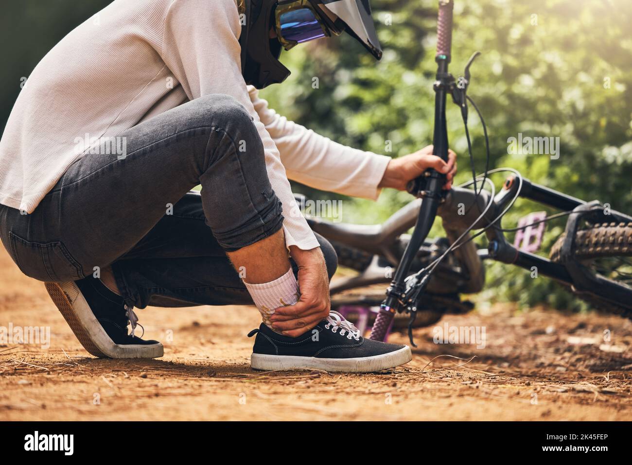Sports bicycle and man with ankle injury on nature cycling trail in ...
