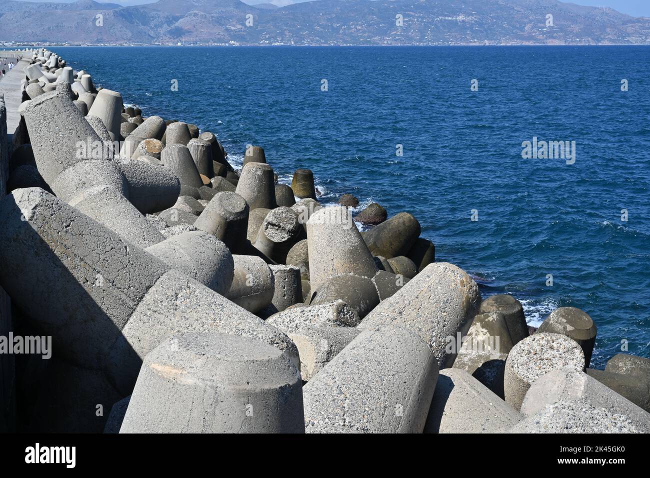 Close view on concrete tetrapod breakwater stones piled up in wave ...