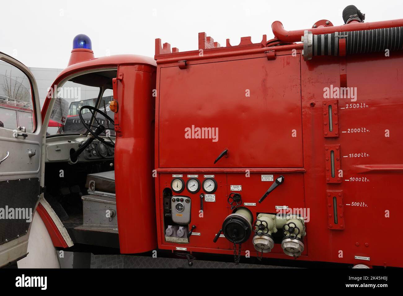 View on vintage red fire-brigade truck with open door of driver cabin ...