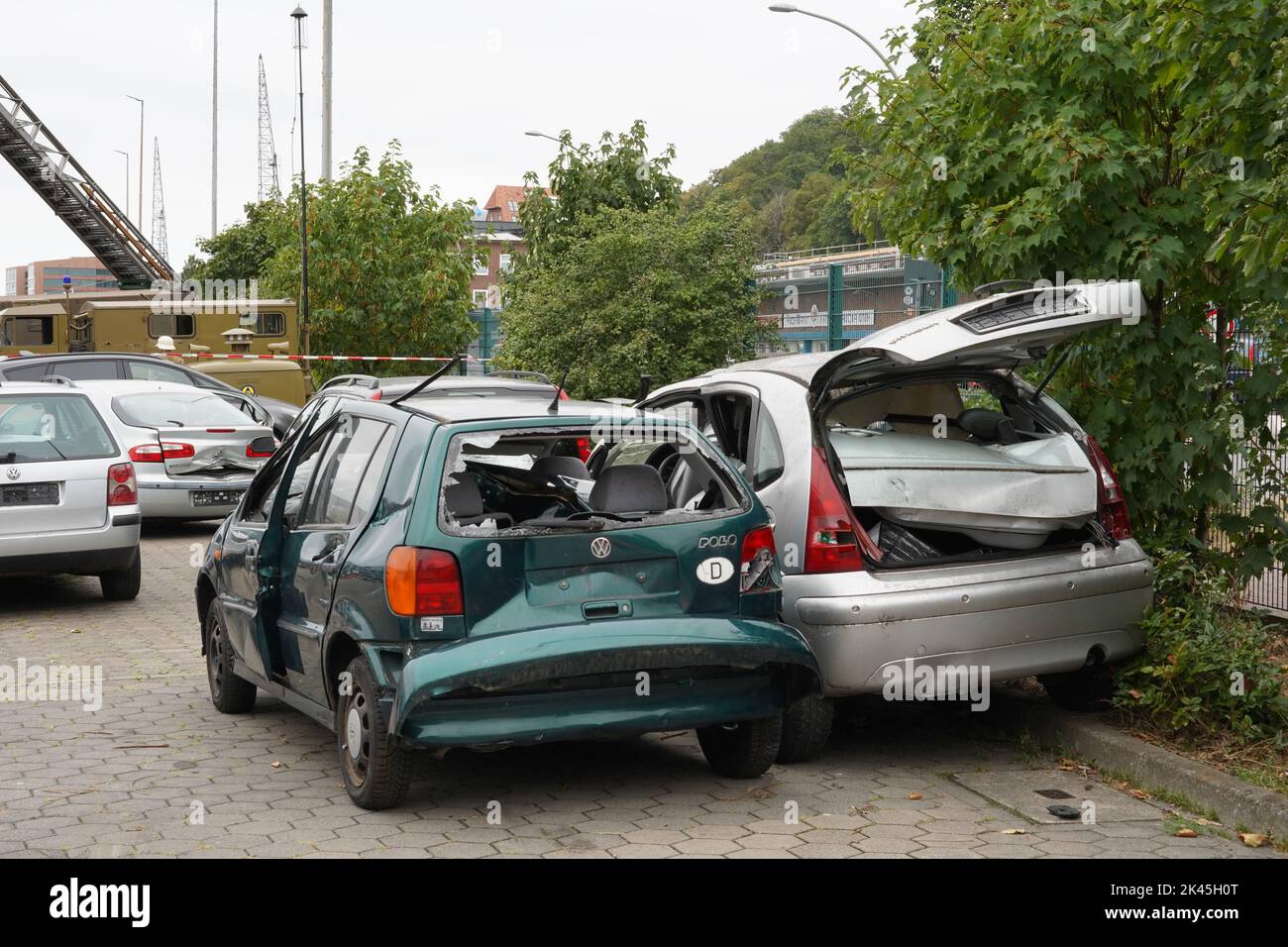 Smashed and wrecked cars of green and silver color on the parking lot ...