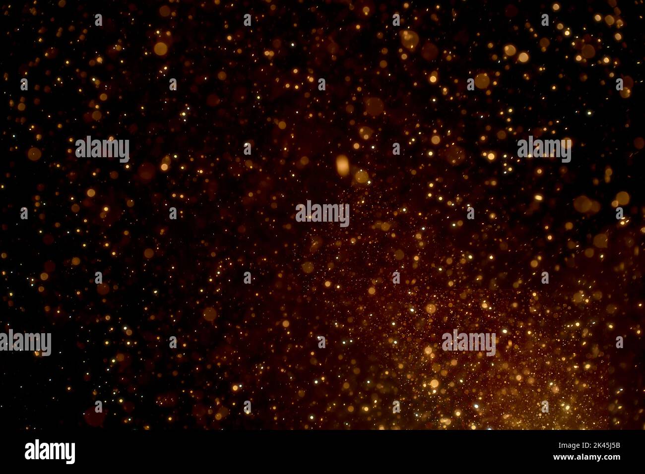 Natural organic golden dust particles floating on black background ...
