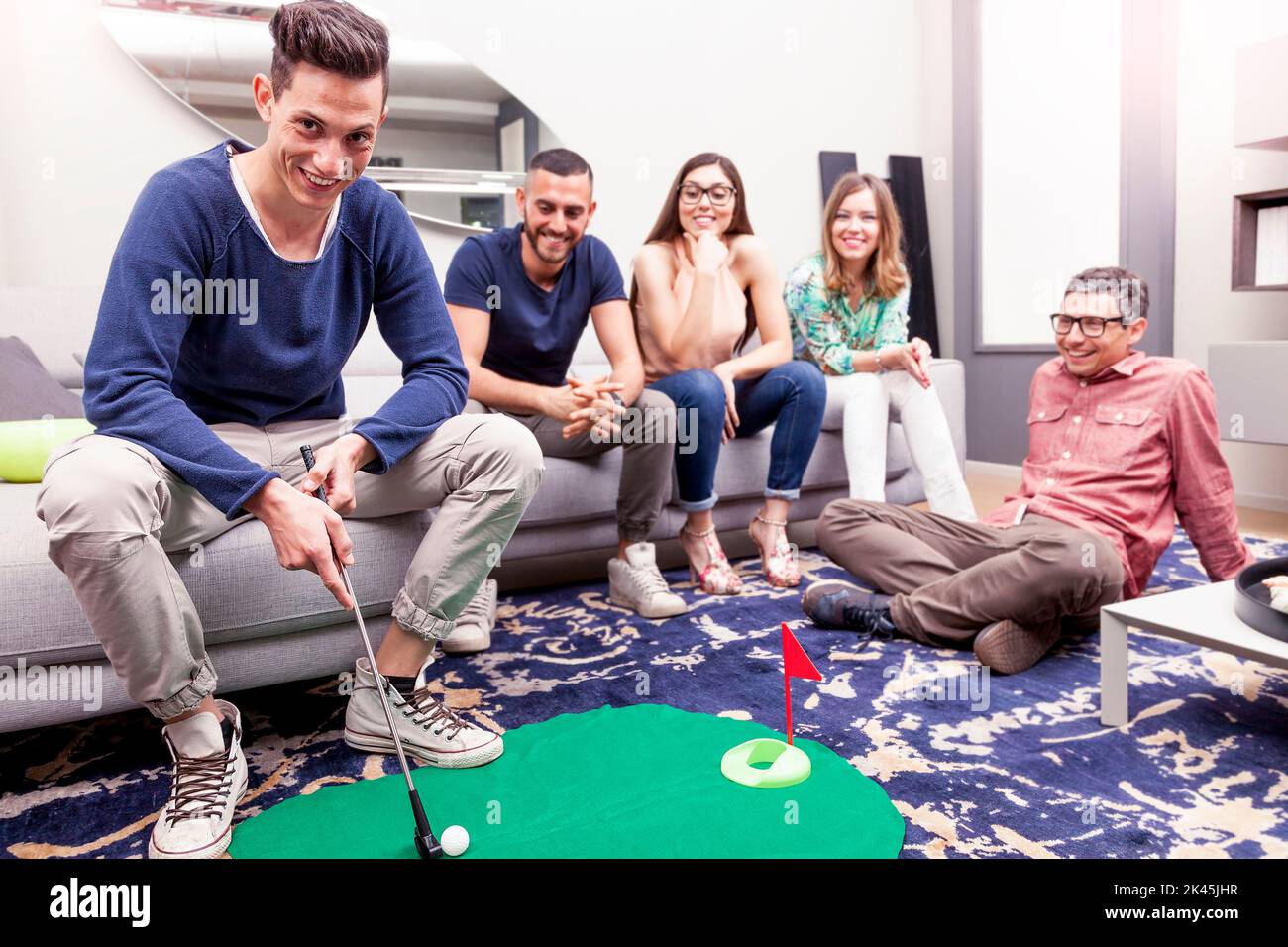 group of young adults have fun playing golf in the living room Stock ...