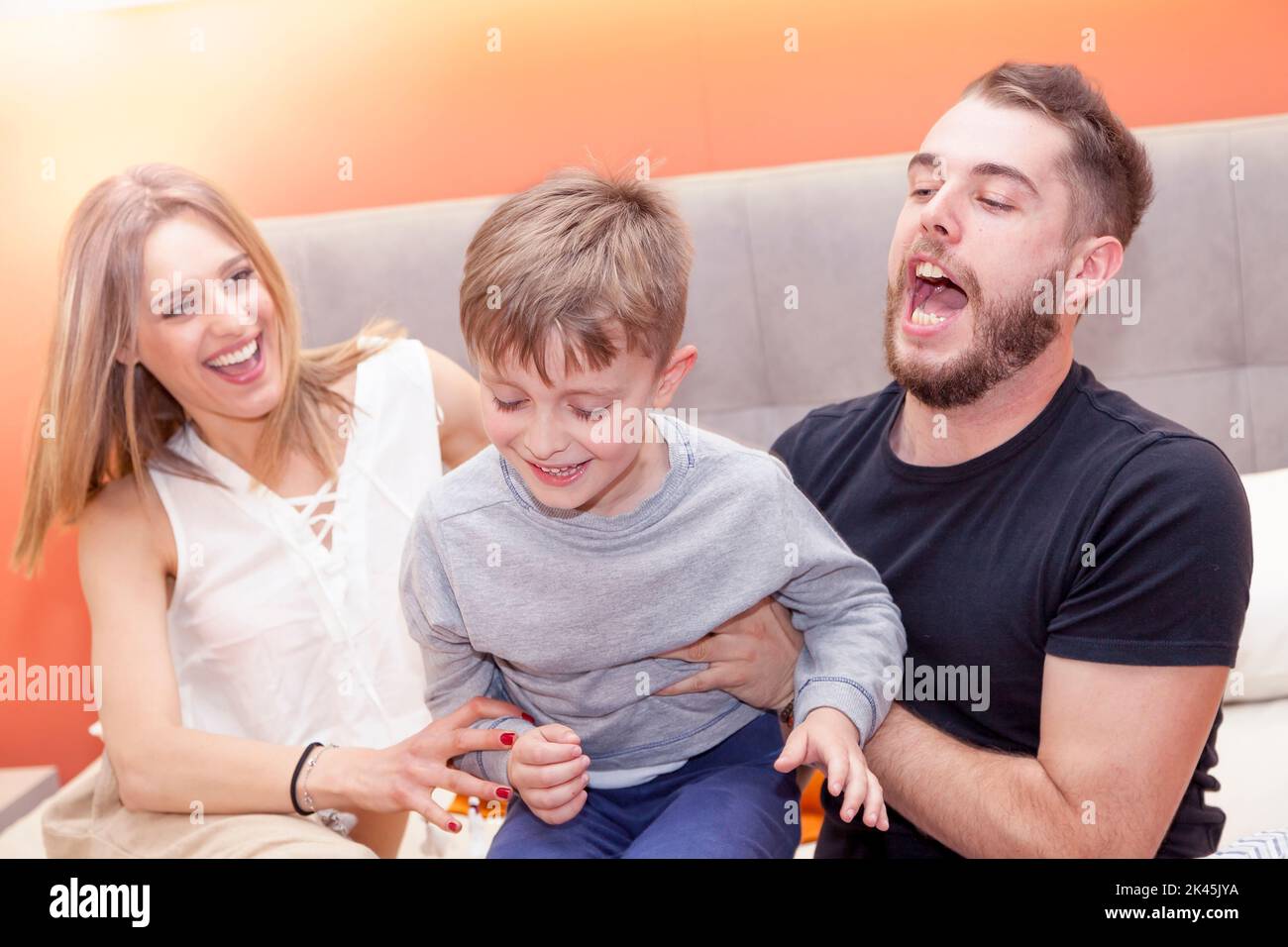 child jokes with parents on the bed in the morning Stock Photo - Alamy