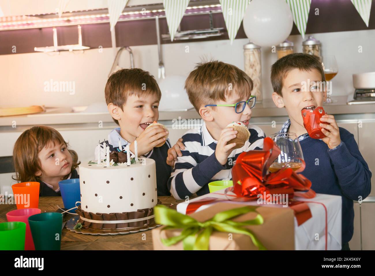 happy kids celebrating around a cake for a birthday Stock Photo - Alamy