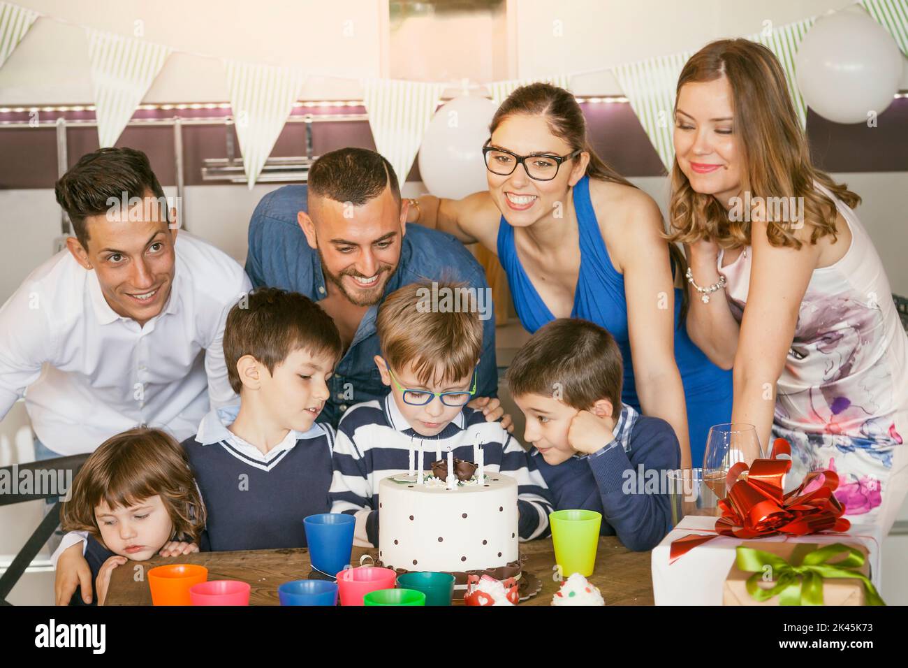 happy families with children celebrating around a cake for a birthday ...