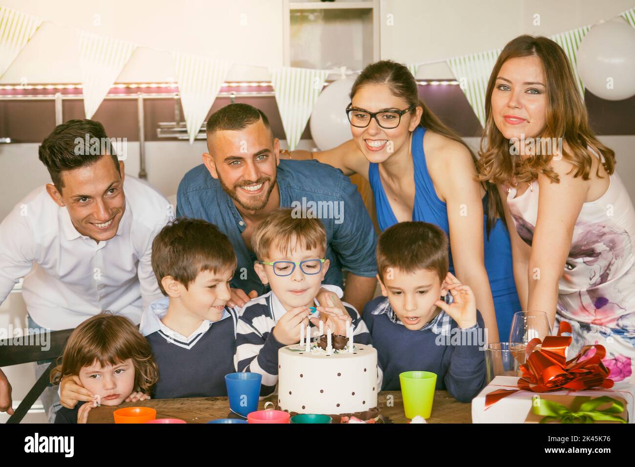 happy families with children celebrating around a cake for a birthday ...
