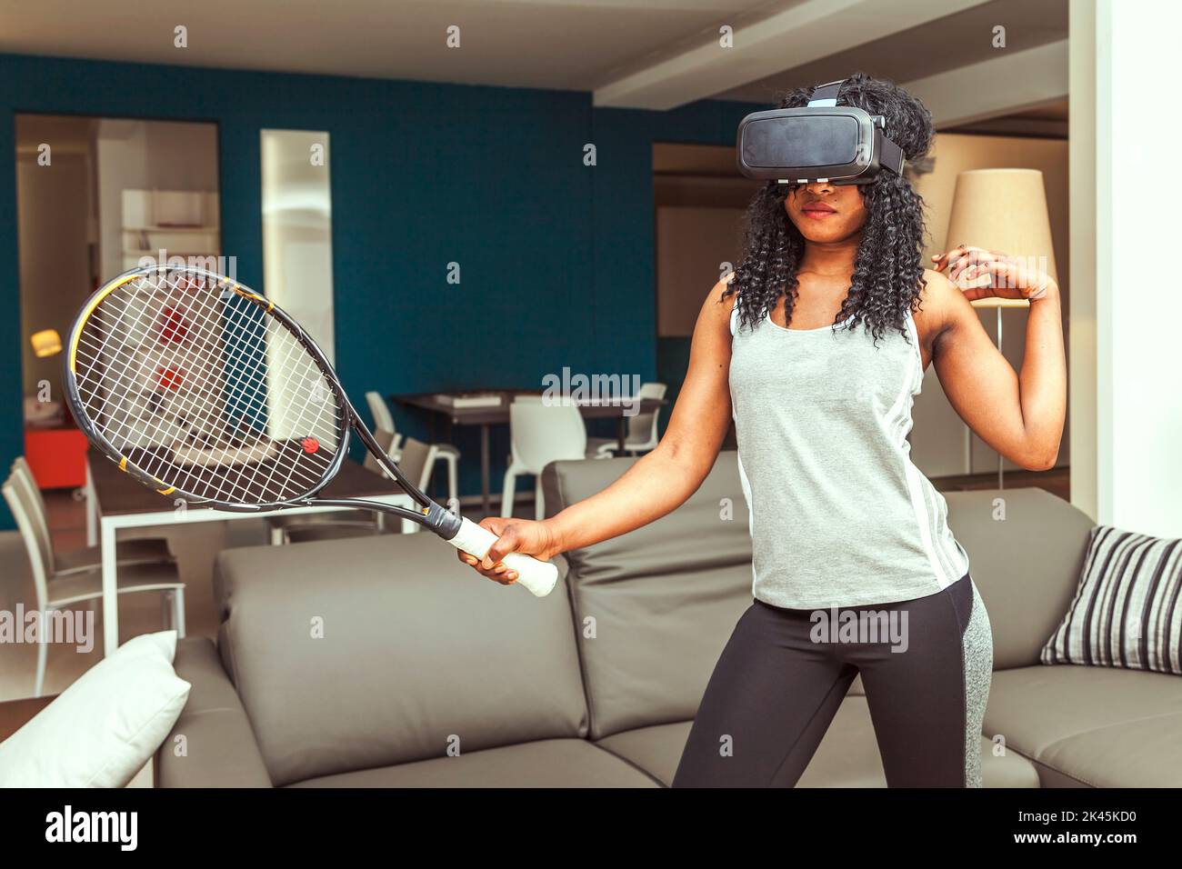 young beautiful woman plays tennis at home in her modern apartment ...