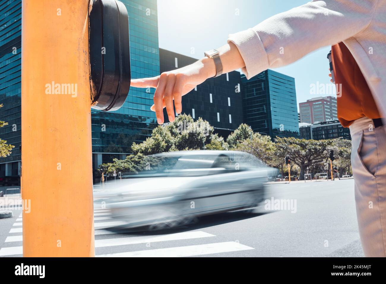 Woman hand pressing a traffic light button at a pedestrian crossing on ...