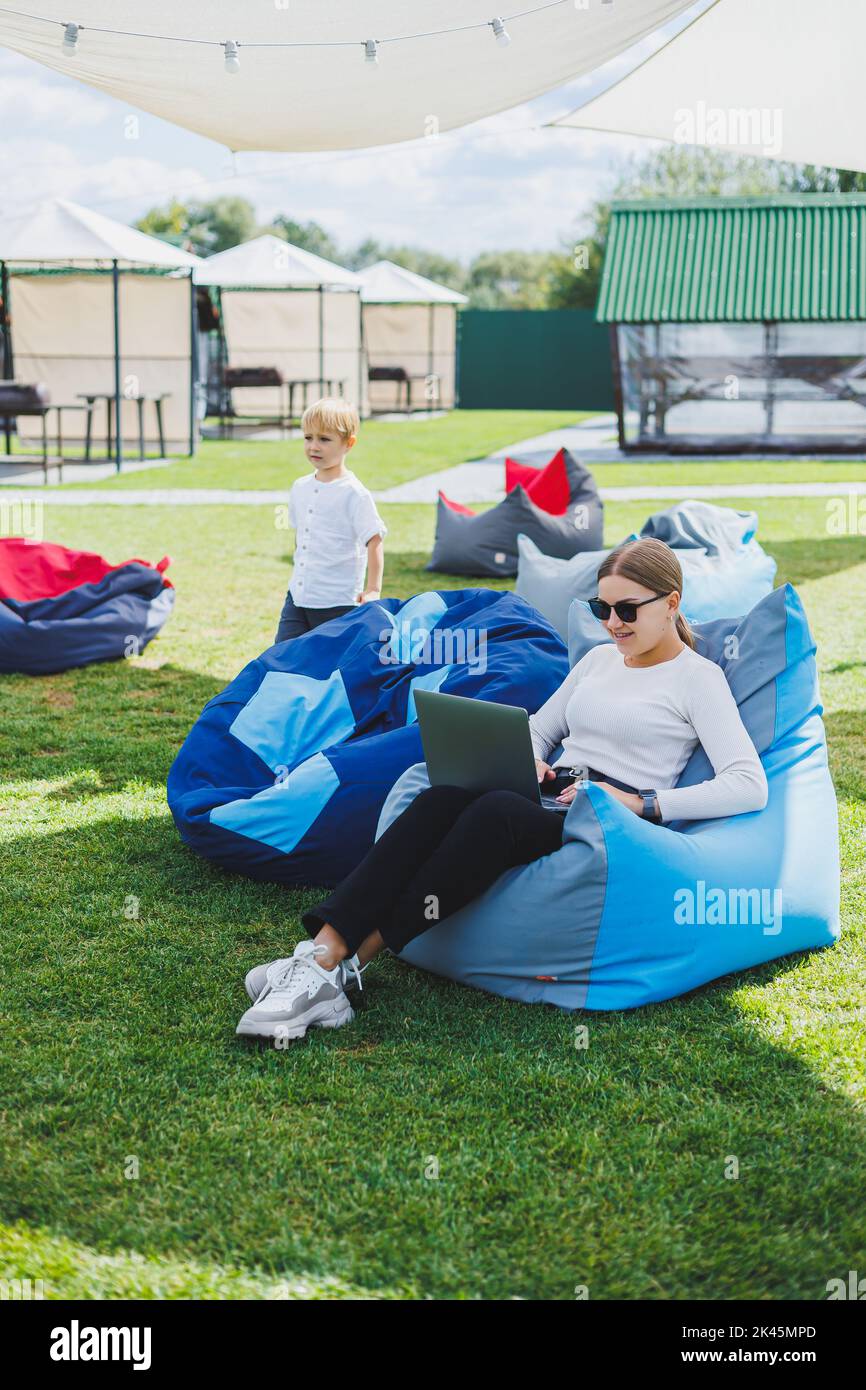 Mother and son on a soft bean bag chair. Mom and son in a bag chair in ...