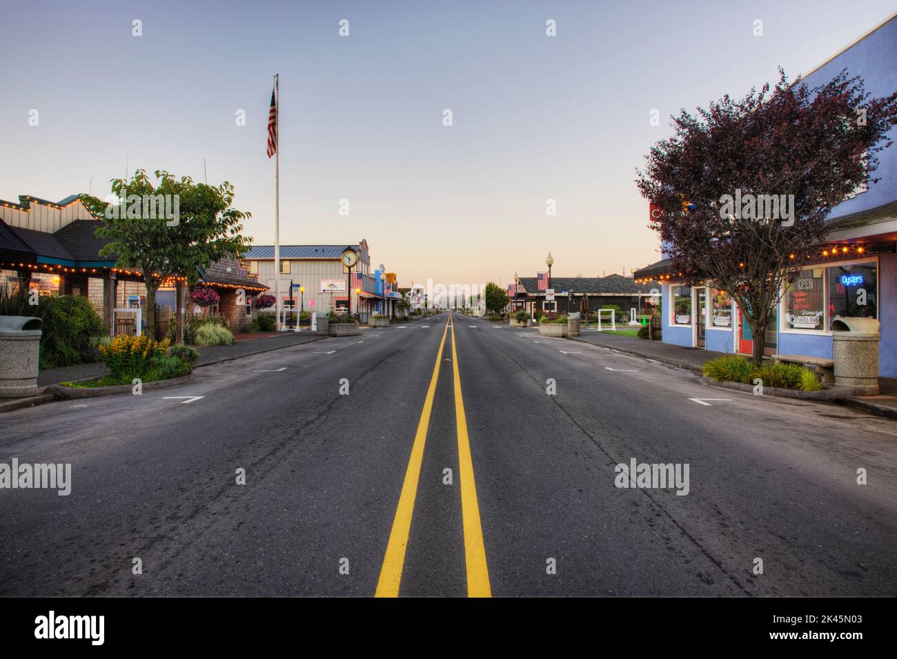 Road on main street running through empty town at dawn Stock Photo - Alamy