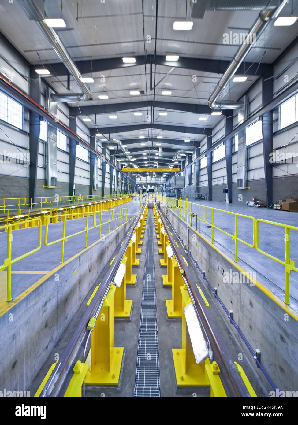 A large covered maintenance yard on a railway, an elevated rail avobe a ...