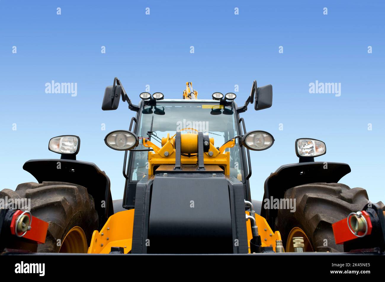 A frontal view of a new modern earth digger vehicle with yellow paint ...