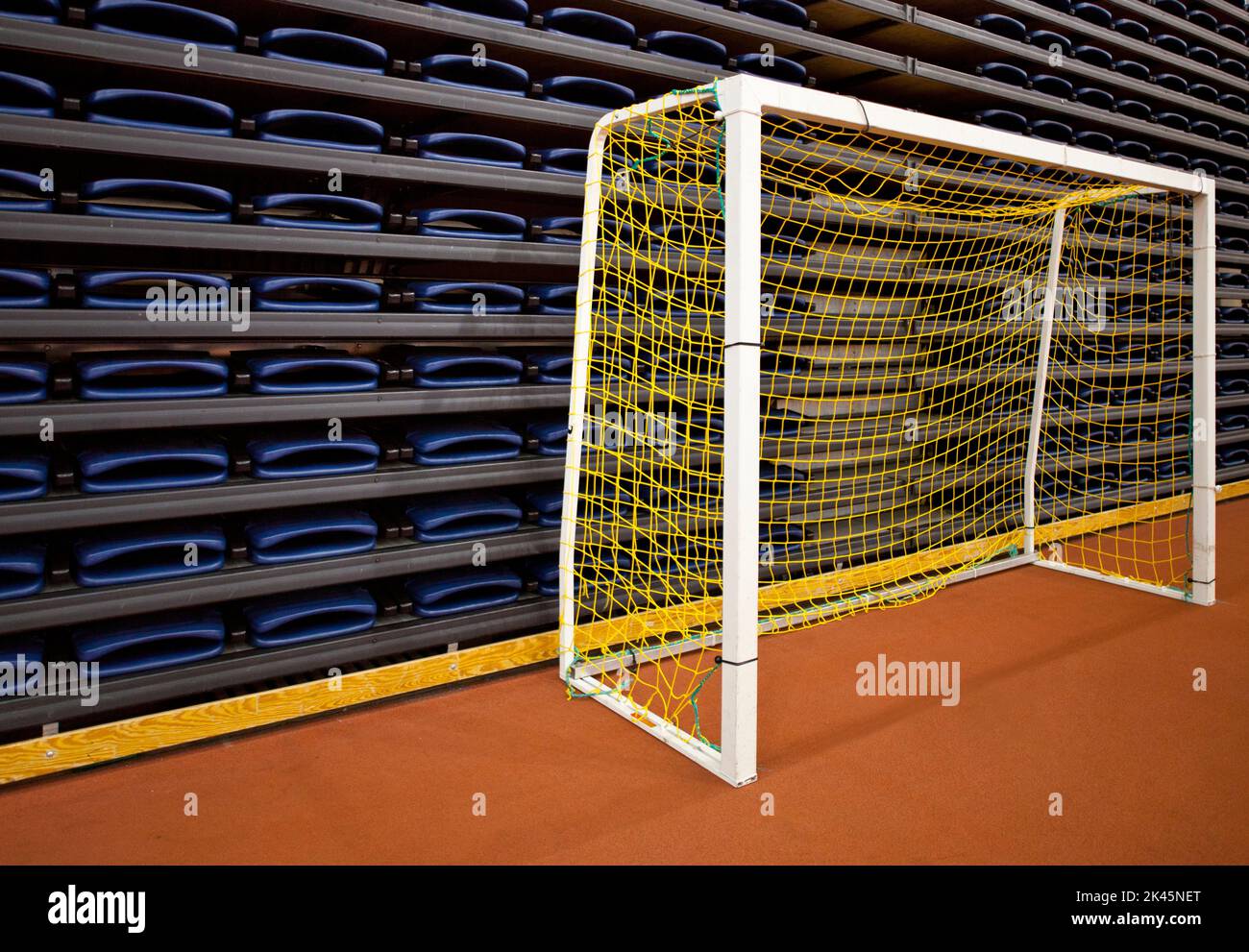 Stack of folded seats at an indoor sports venue, and a practise ...