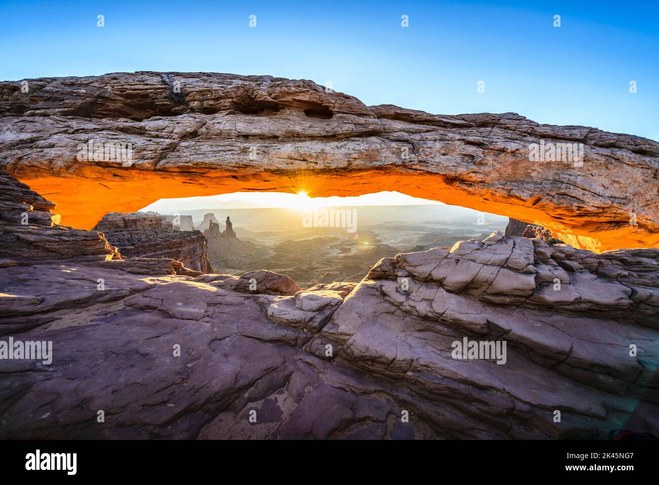 Sunrise at Mesa Arch in Canyonlands National Park at sunrise, the sun lighting the glowing ...
