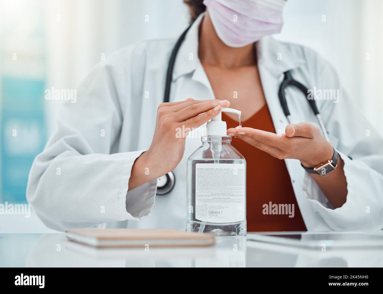Covid, hand sanitizer and doctor woman in hospital office for hand ...