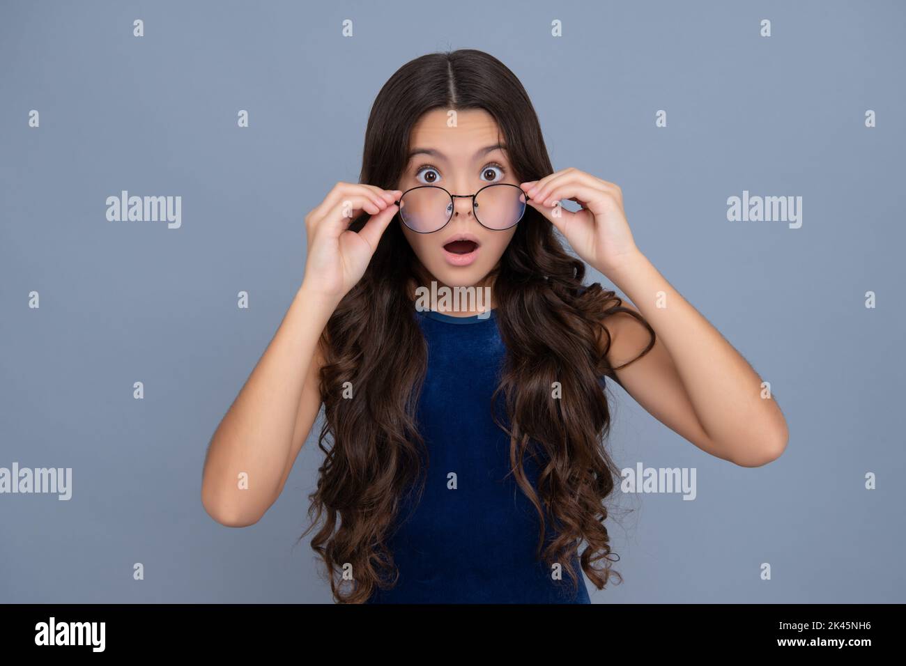 Cute school girl wearing glasses on yellow studio background, smart ...