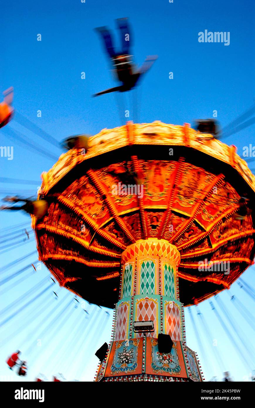 People riding on a chair swing ride or swing carousel seen from below ...