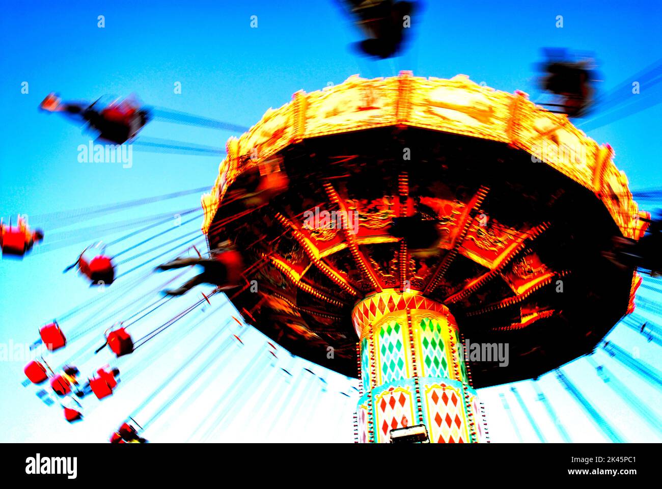 People riding on a chair swing ride or swing carousel seen from below ...